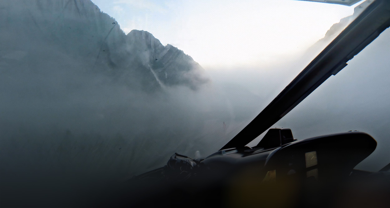 View through the windshield of a helicopter flying through extreme snowy conditions